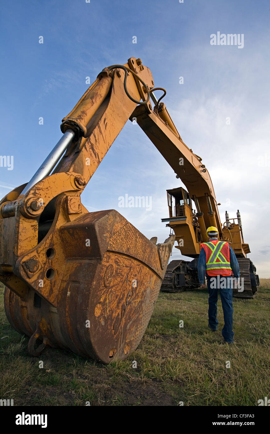 Heavy equipment operator walking next to excavating machine Stock Photo ...