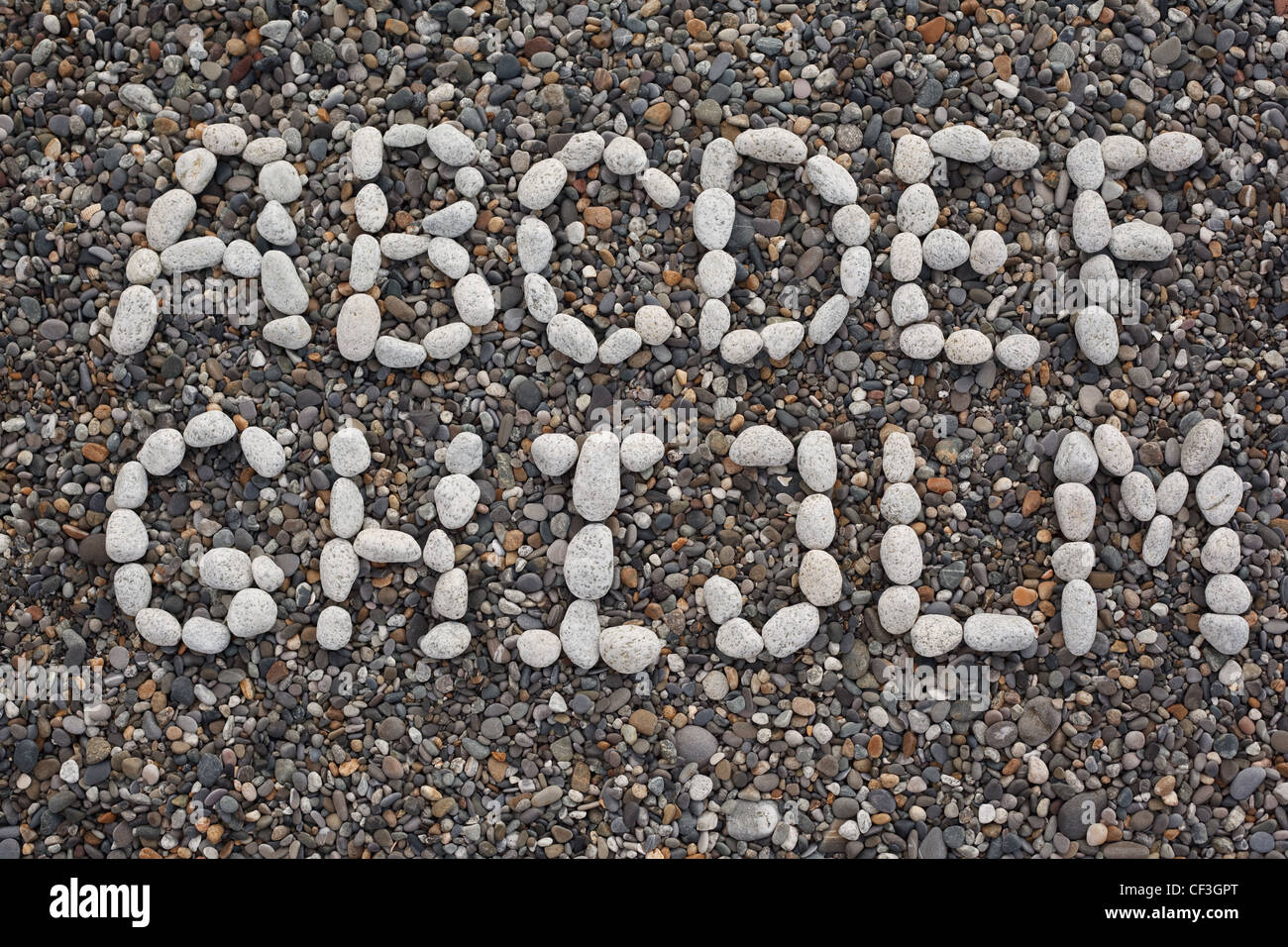 Beach, letters of alphabet made of white stones on dark pebbles. First ...