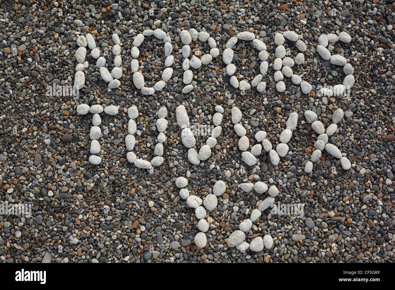 Beach, letters of alphabet made of white stones on dark pebbles. Second ...