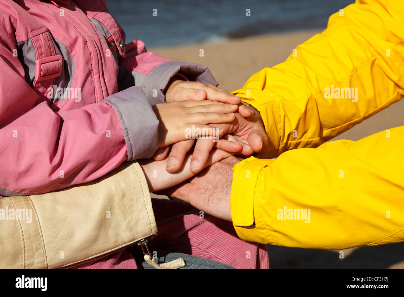 The connected hands of family as support and unity sign. Three people ...