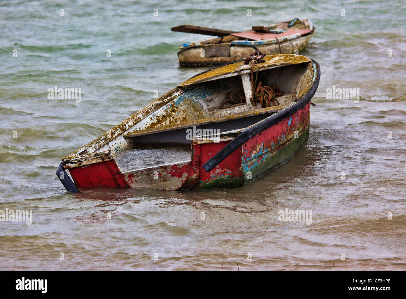 Two dinghies sinking at moorings Stock Photo - Alamy