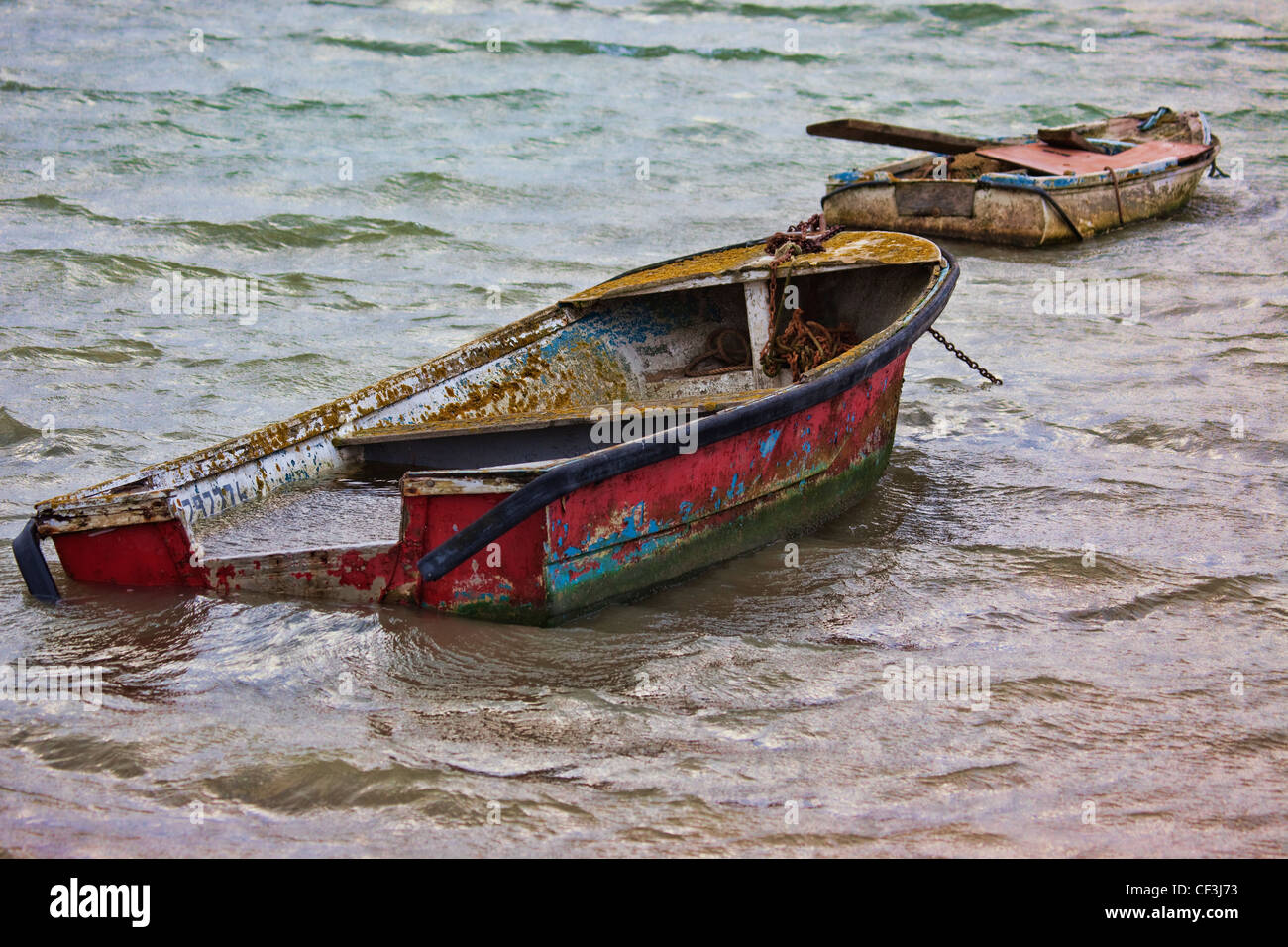 Two dinghies sinking at moorings Stock Photo - Alamy
