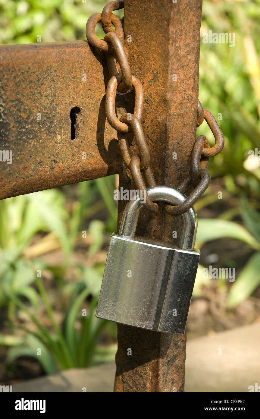 A close up of a padlock and chain around the upright of an open iron ...