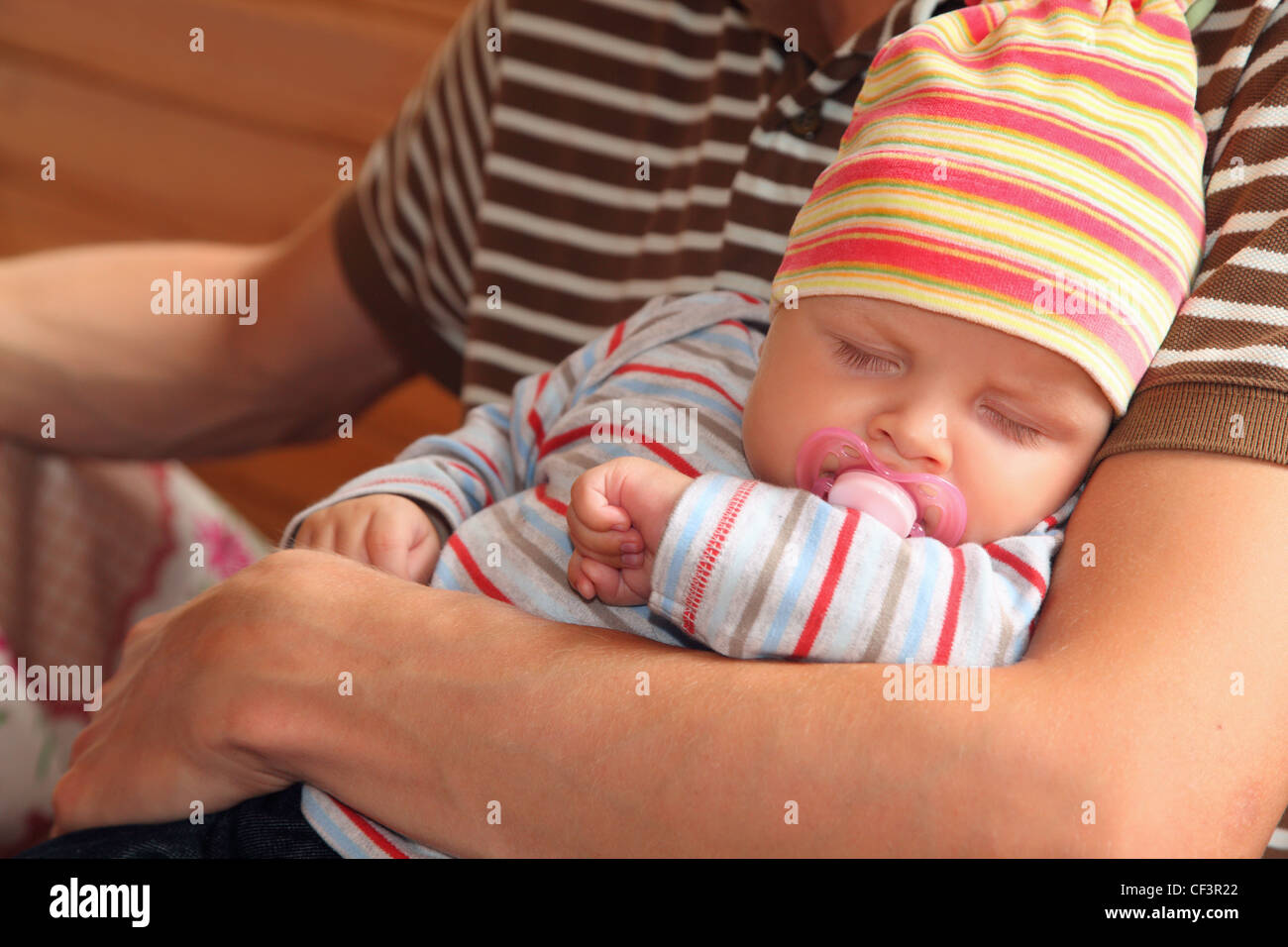baby sleeping on hands of man Stock Photo - Alamy