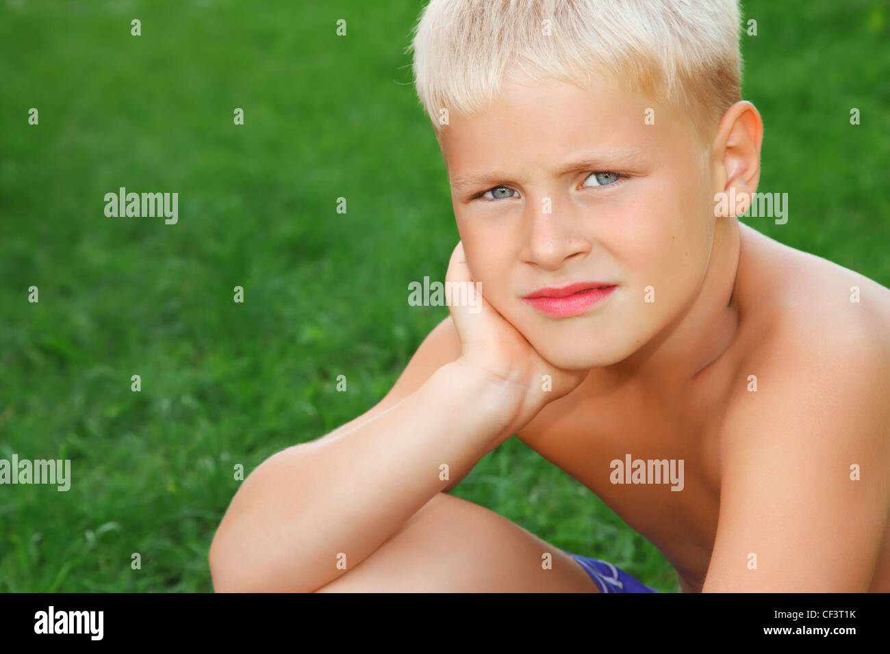 sad boy sitting on meadow Stock Photo - Alamy