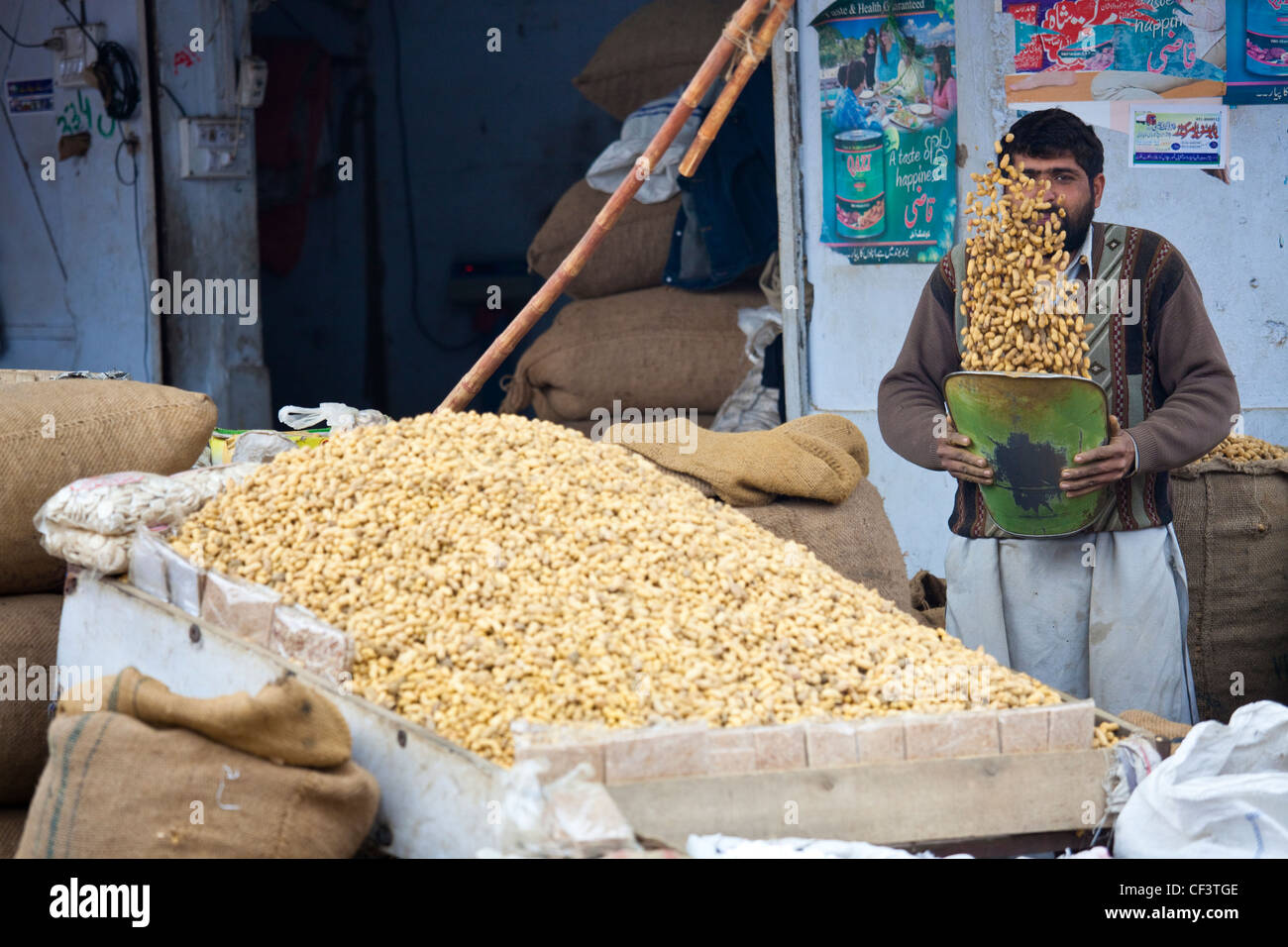 Nut vendor removing loose shells from peanuts, Islamabad, Pakistan ...