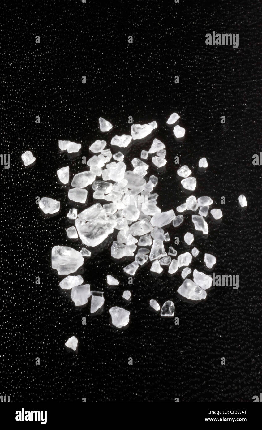 Pile of sea salt crystals against black textured black background Stock ...