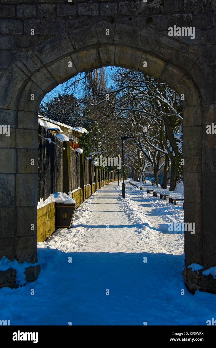 View through an arch along the snow covered path by the River Ouse ...