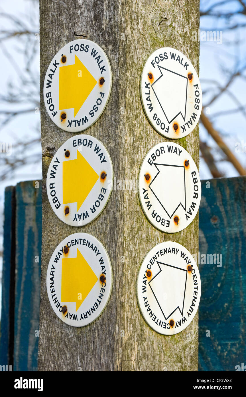 Signs on a wooden post with arrows showing directions for Centenary Way ...