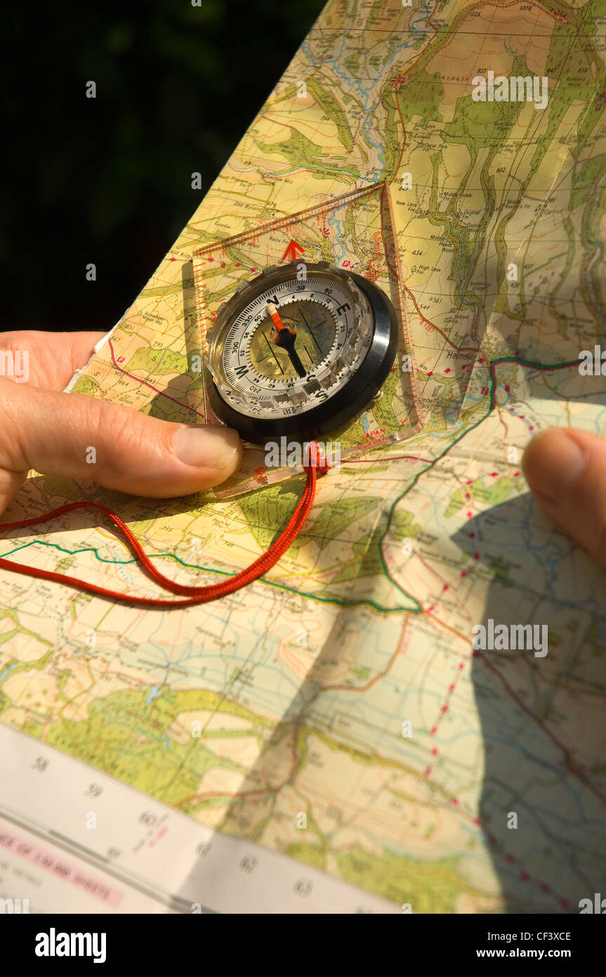 A man holding a walking map and compass Stock Photo - Alamy