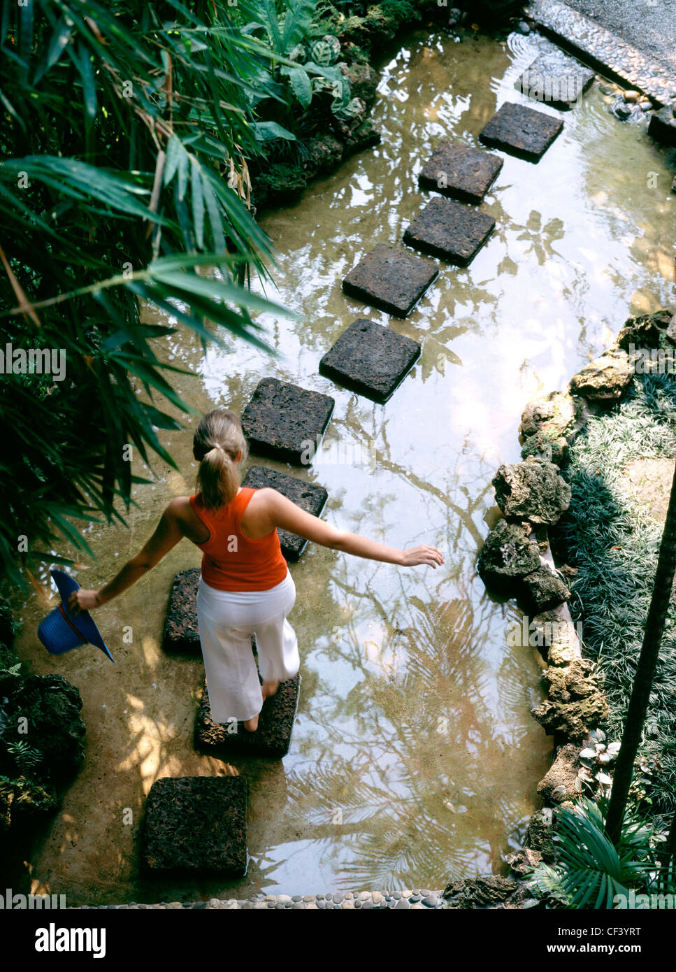 Thai Spa View from above of female walking across stepping stones over ...