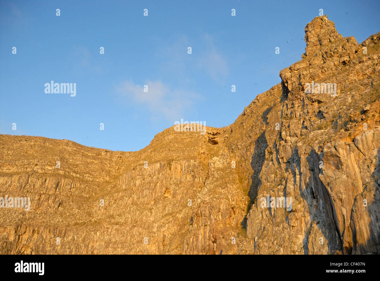 Rocky cliffs of Wolf (or Wenman) Island at sunset, Galapagos Islands ...