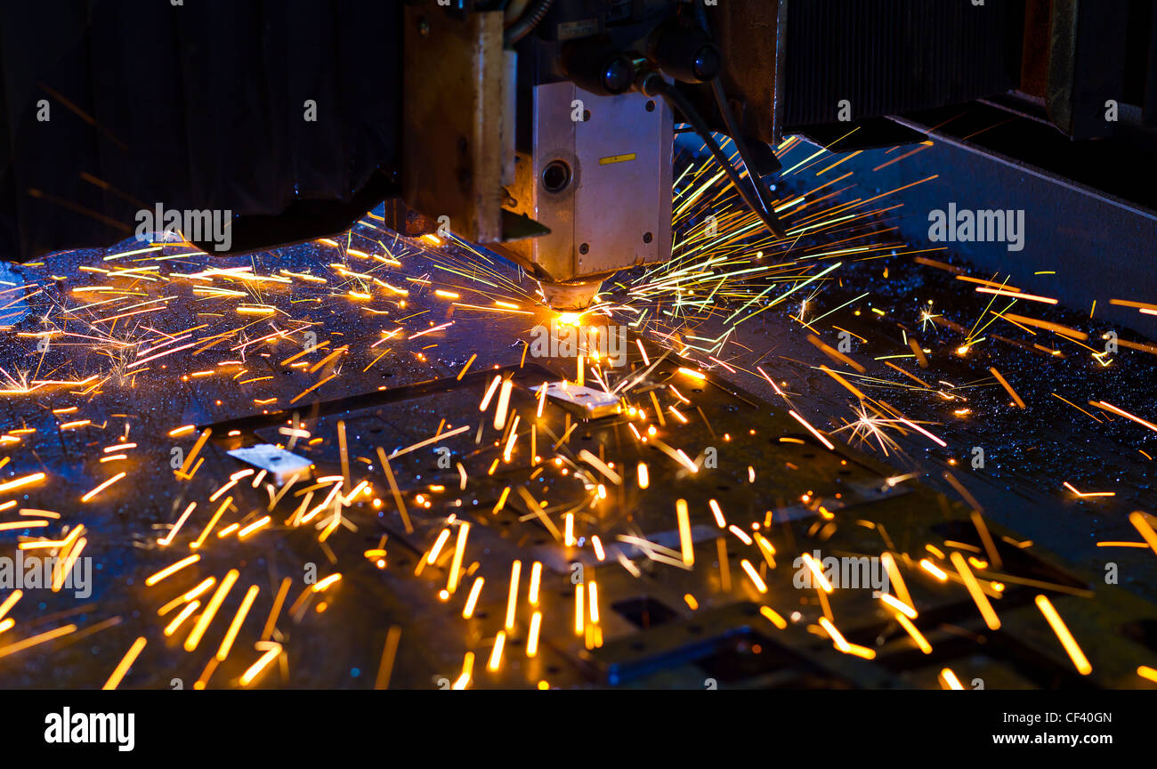 Laser cutting with sparks close up Stock Photo - Alamy