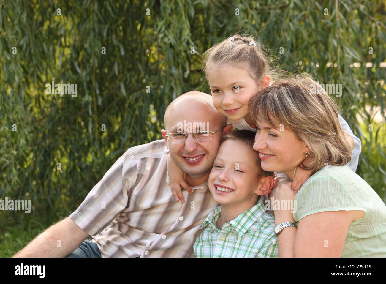 cheerful family with two children in early fall park. father, mother ...