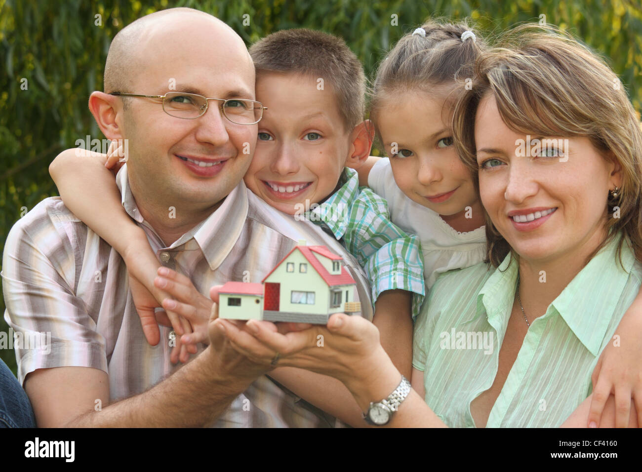 smiling family two children is keeping wendy house their hands looking ...