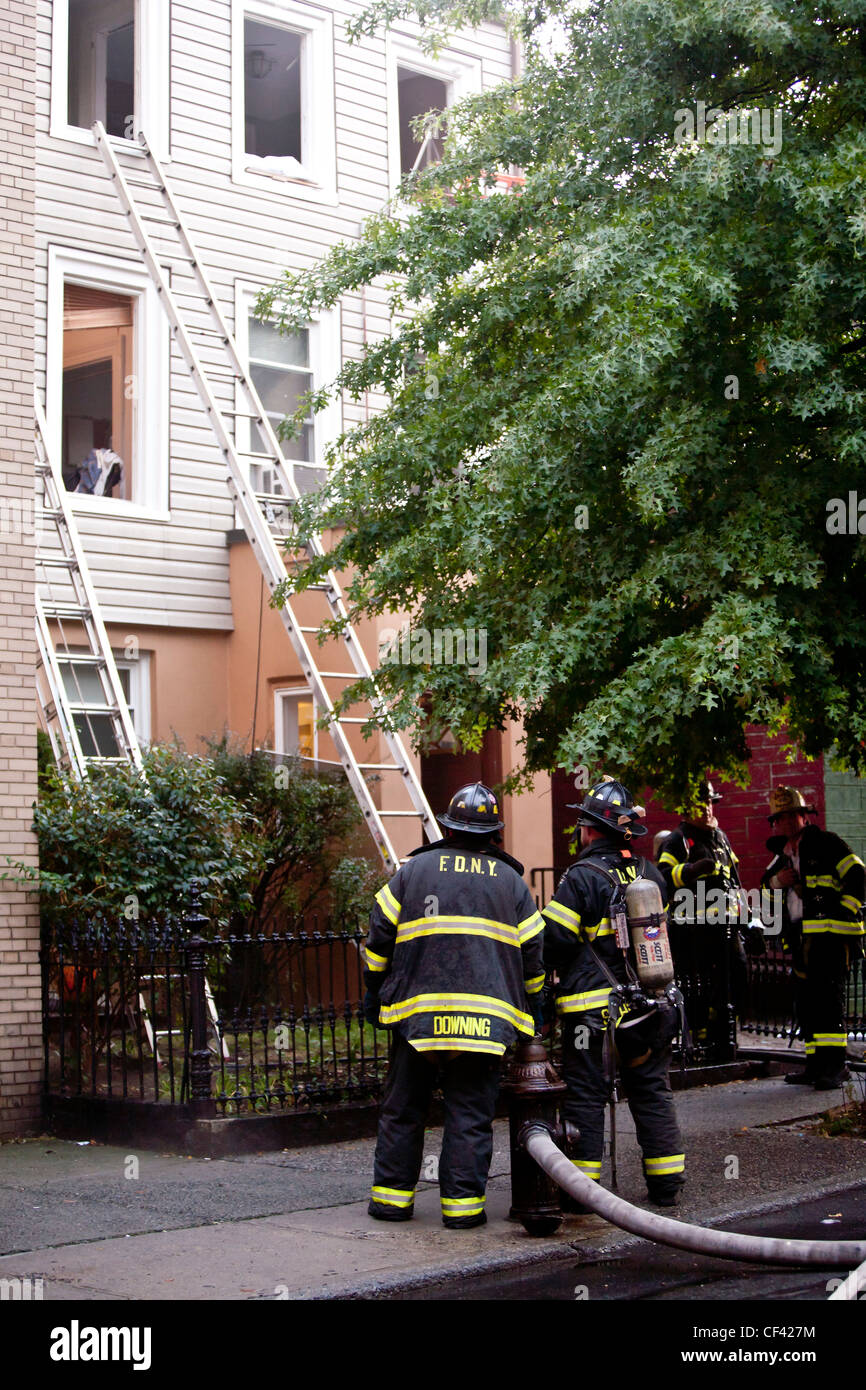 Firemen getting ready to climb the latter to put down fire in one of ...