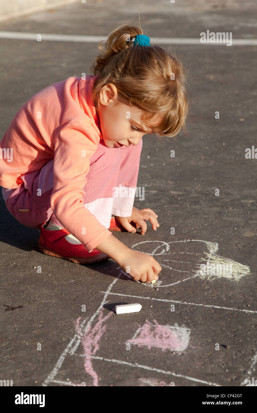 girl sits concrete asphalt square road girl draws painting line house ...