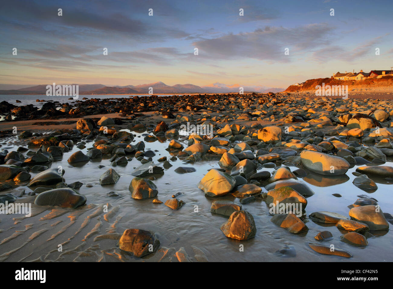 Sunset across the bolder-strewn beach at Llanganwg with the Lleyn ...