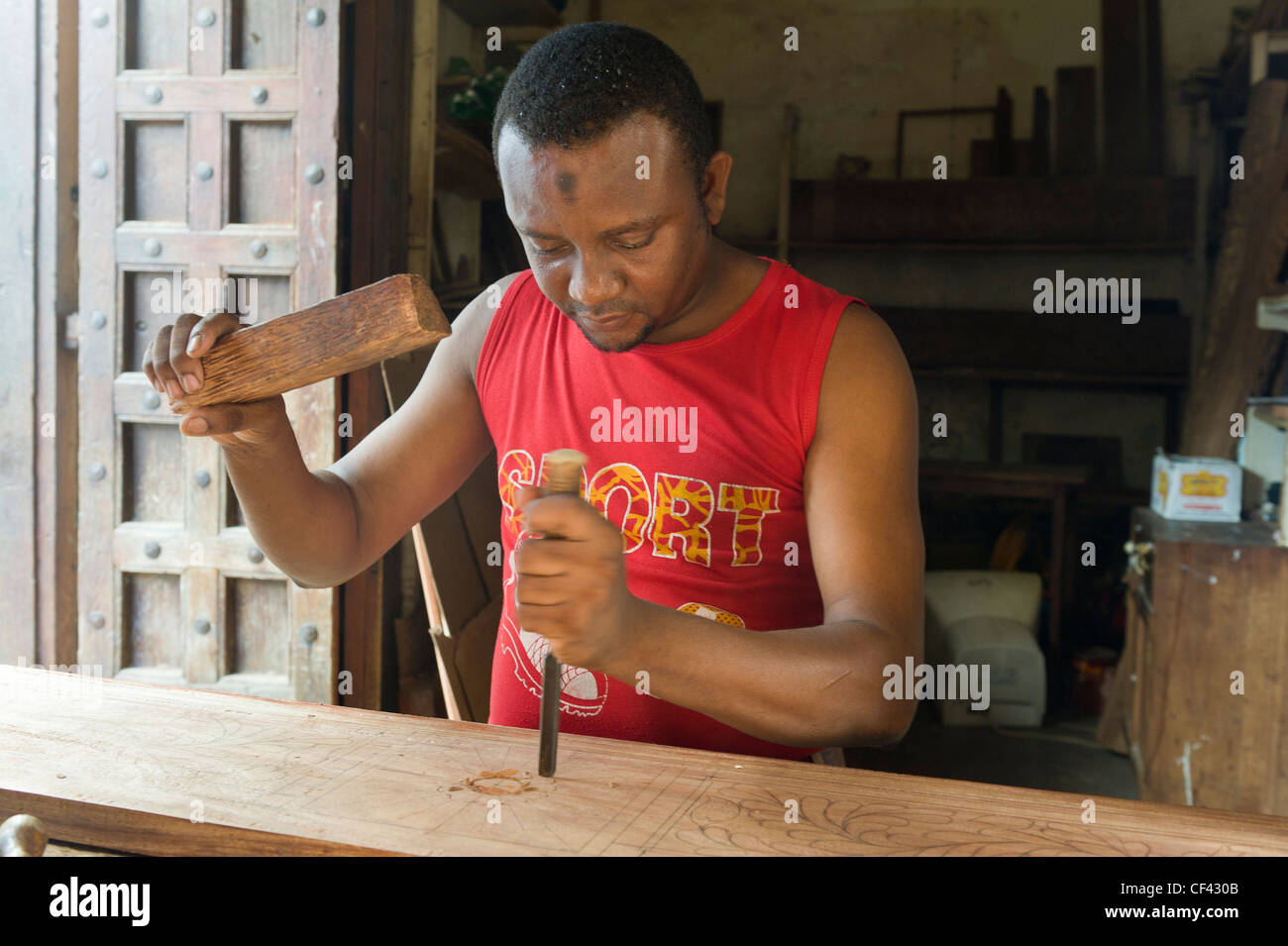 Carpenter carving an ornate frame for a bed Stone Town Zanzibar ...