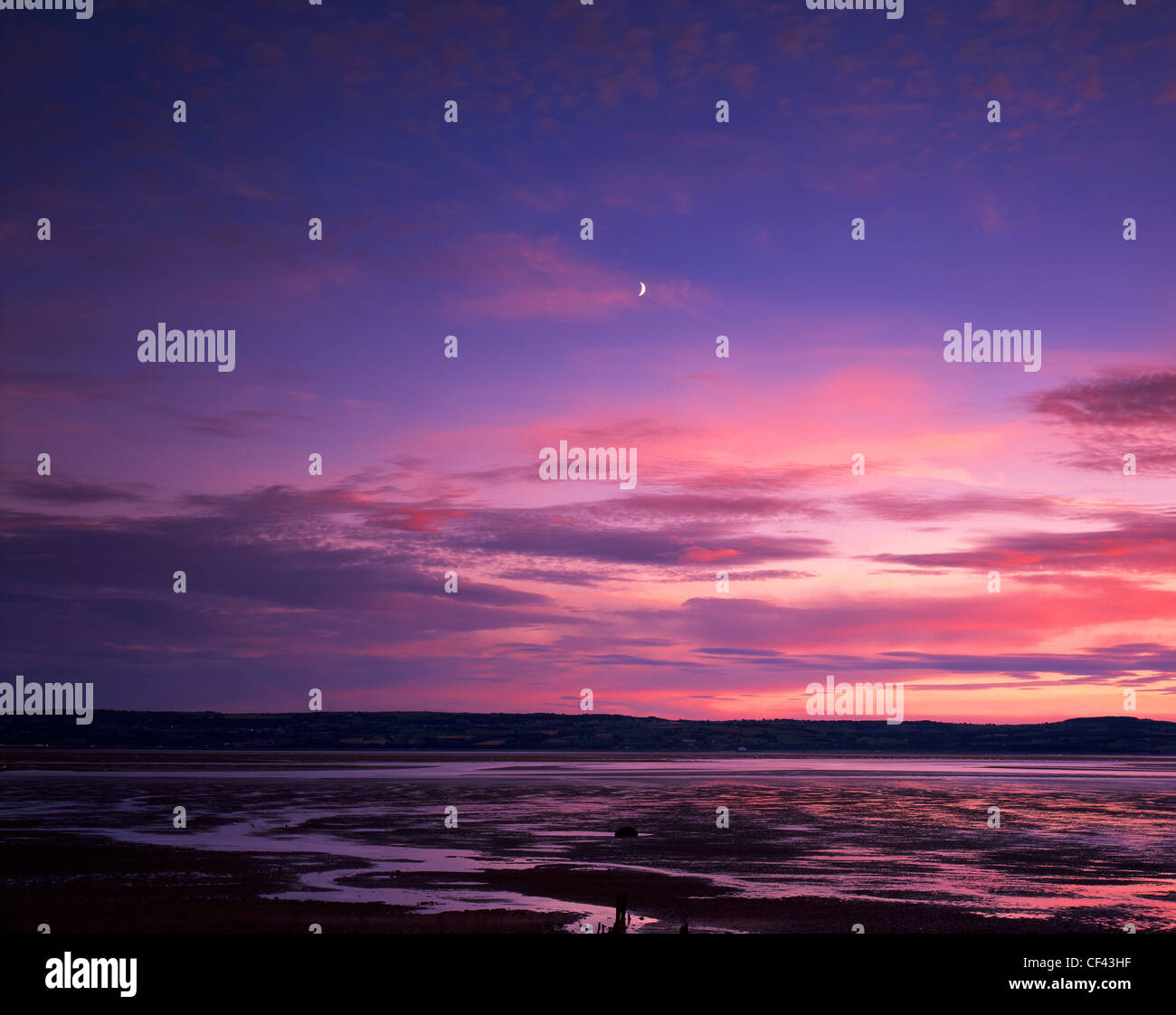 A crescent moon over the Dee Estuary looking towards north Wales from ...