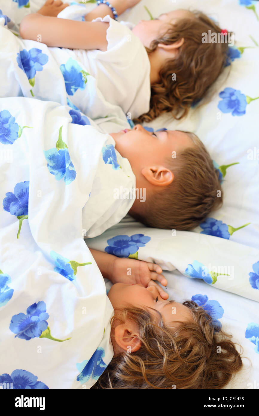 children three together sleeping on bed in cosy room Stock Photo - Alamy