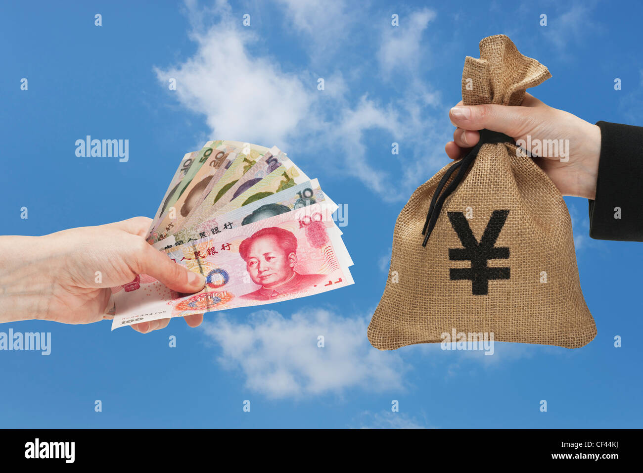 Diverse Chinese Yuan bills are held in the hand. At the other side a ...