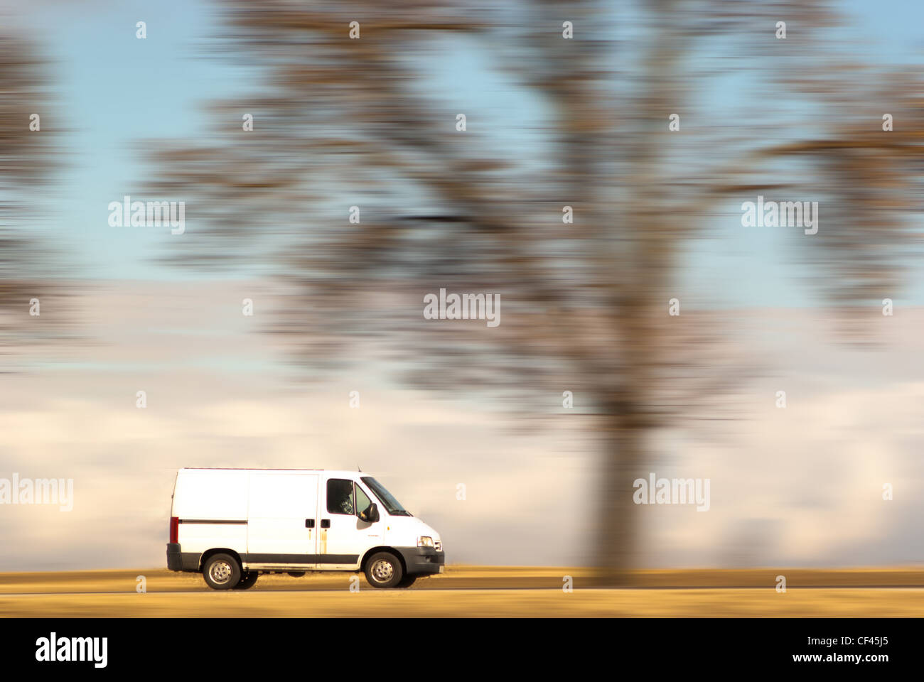 car on road between yellow and green trees with cloudy sky Stock Photo ...