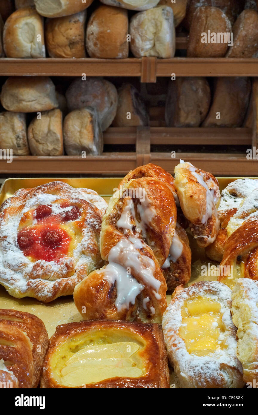 Viennoiseries on display and shelves with loaves of fresh baked bread ...