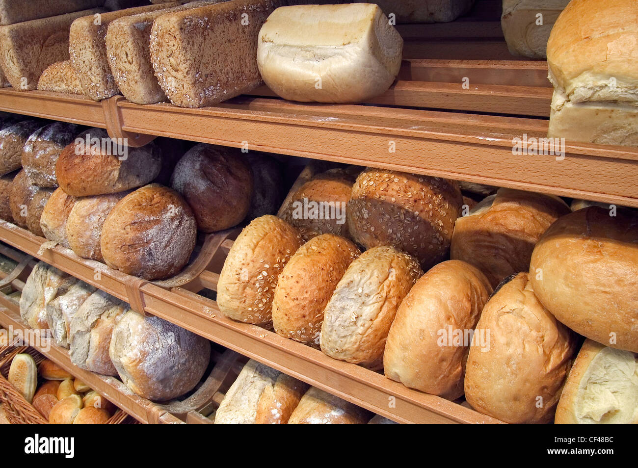 Shelves with loaves of fresh baked bread on display in bakery shop ...