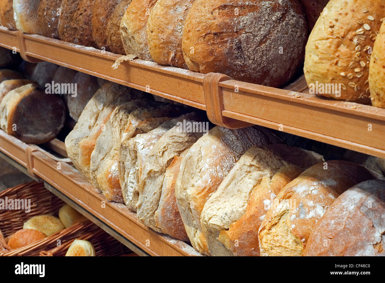 Shelves with loaves of fresh baked bread on display in bakery shop ...