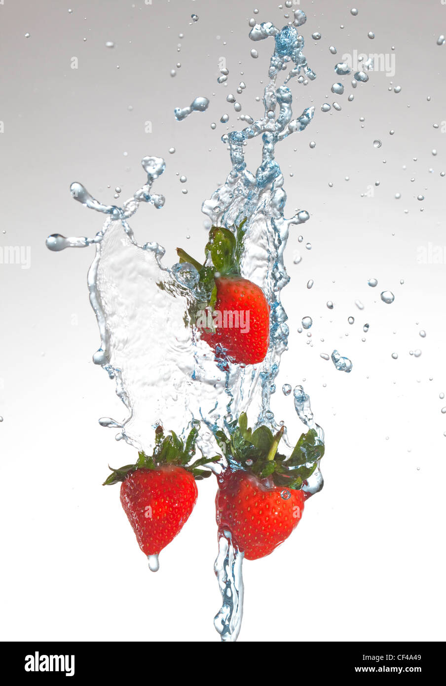 three strawberries splashed with water Stock Photo - Alamy
