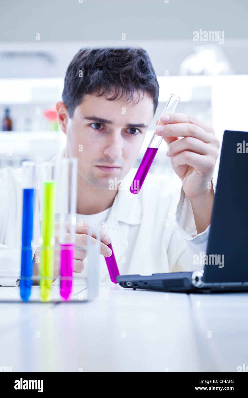 close-up portrait of a young male researcher carrying out experiments ...