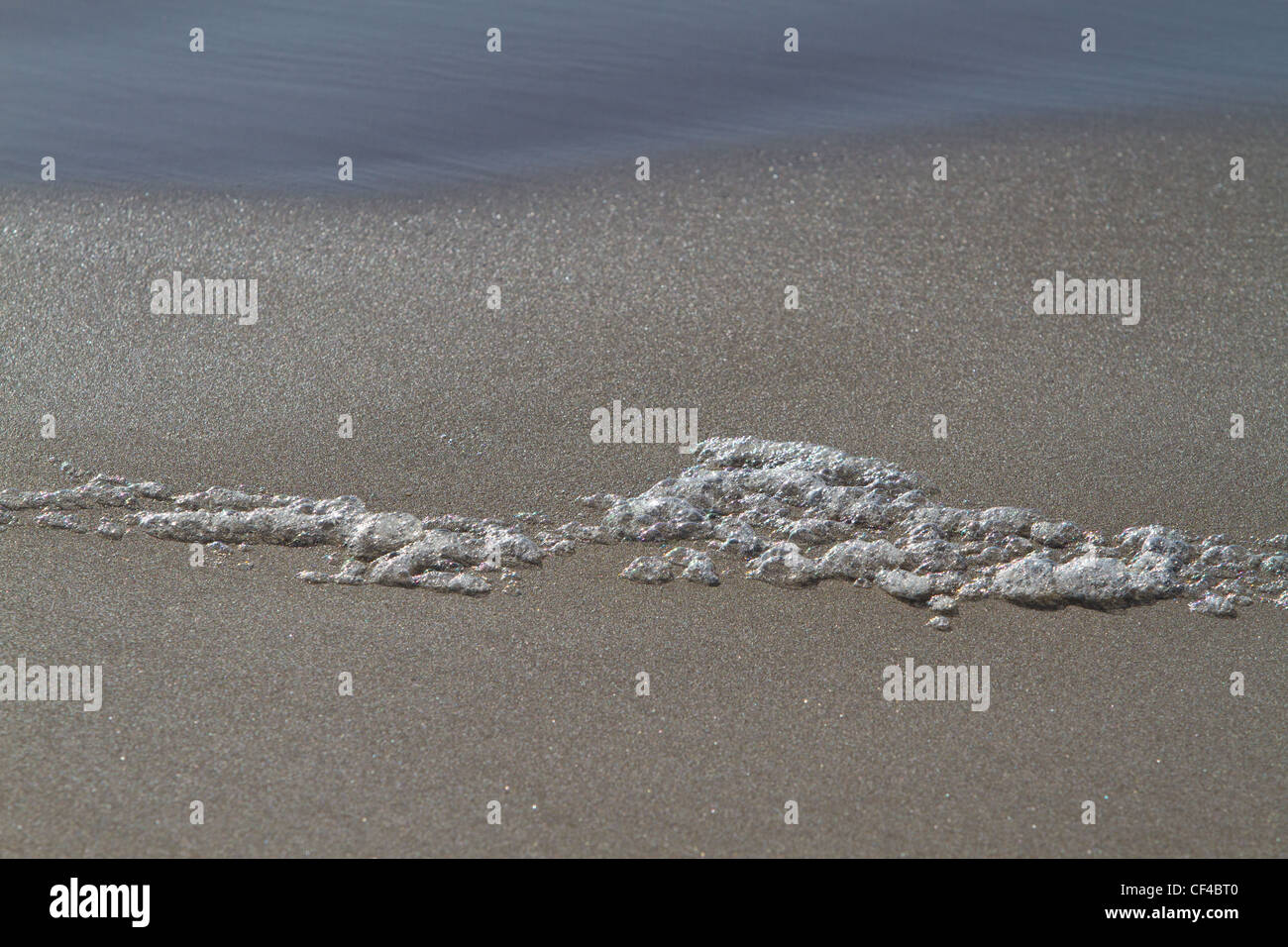 Foam on the beach Stock Photo - Alamy