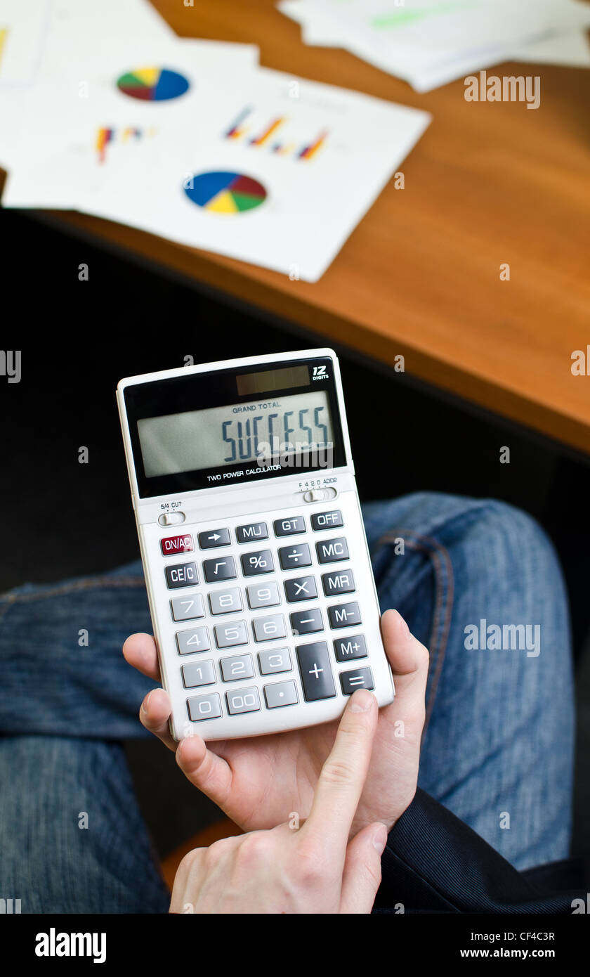 Calculator with success word on it display holded by bussinessman in his office Stock Photo - Alamy