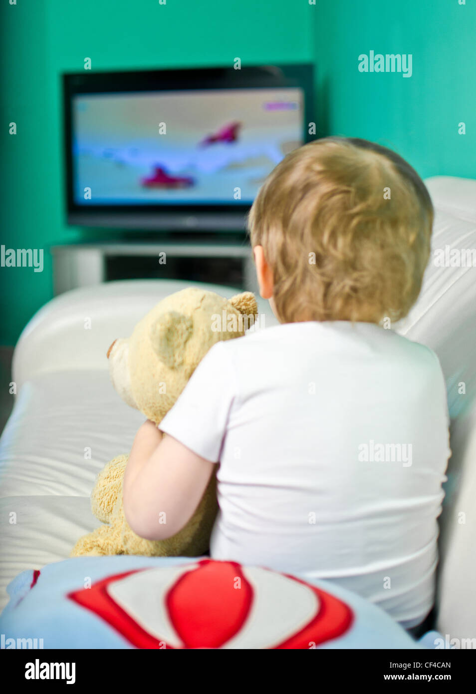 Kid with teddy bear watching TV Stock Photo - Alamy