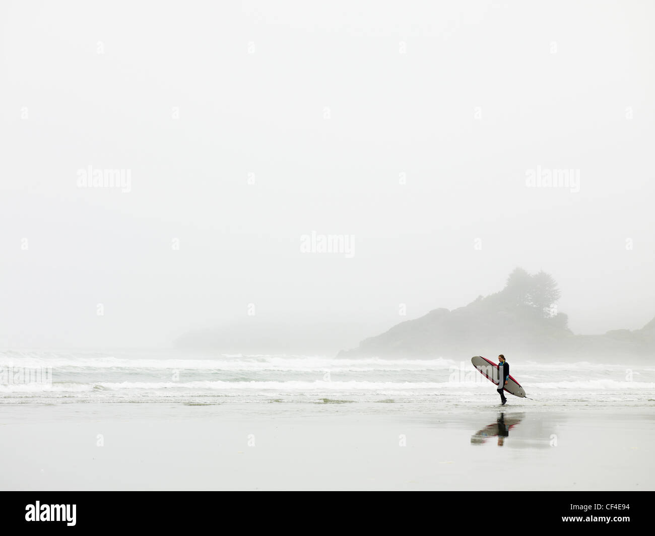 Surfer Walking On The Beach In Cox Bay; Tofino British Columbia Canada ...