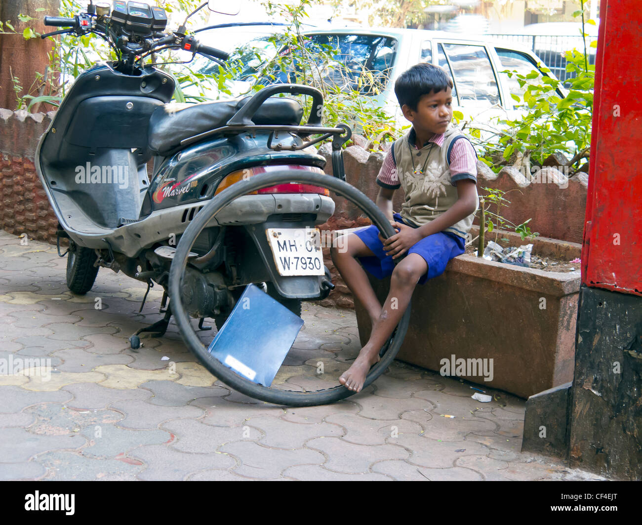 homeless boy resting after playing with a cylce tire on the streets of ...