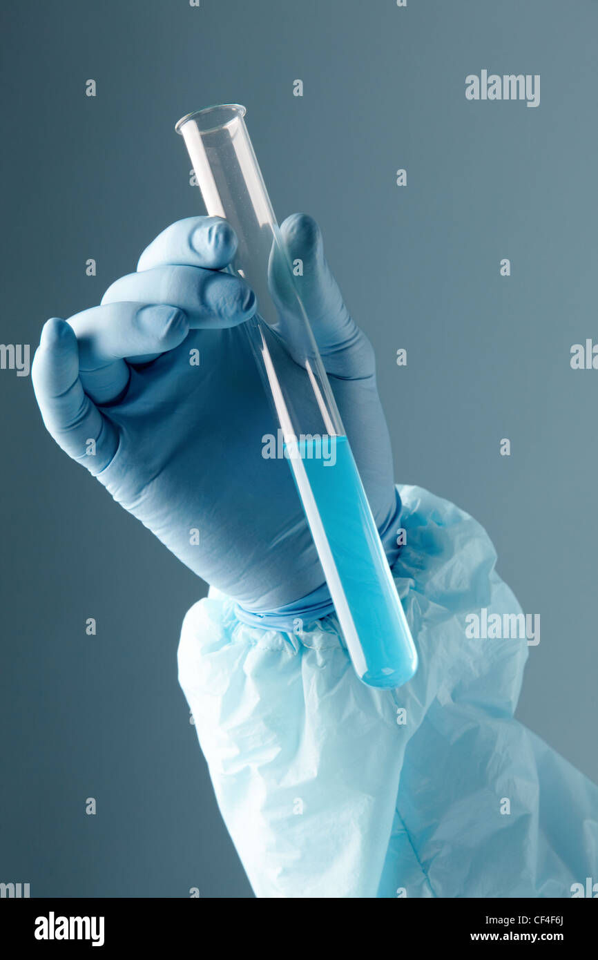 Vertical shot of hand holding a tube with blue liquid Stock Photo - Alamy
