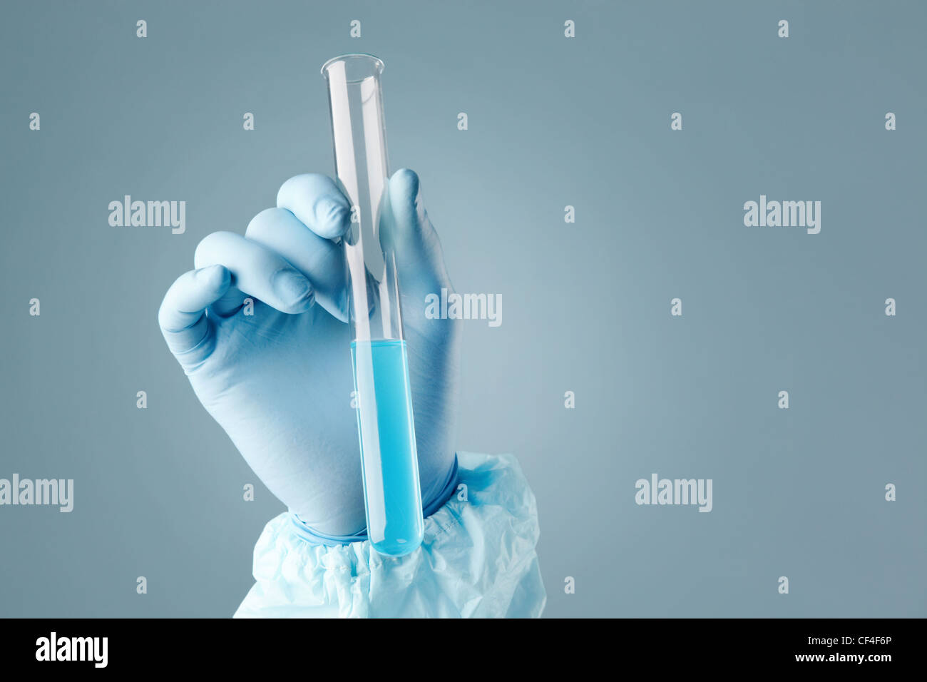 Hand holding a test-tube with cyan liquid Stock Photo - Alamy