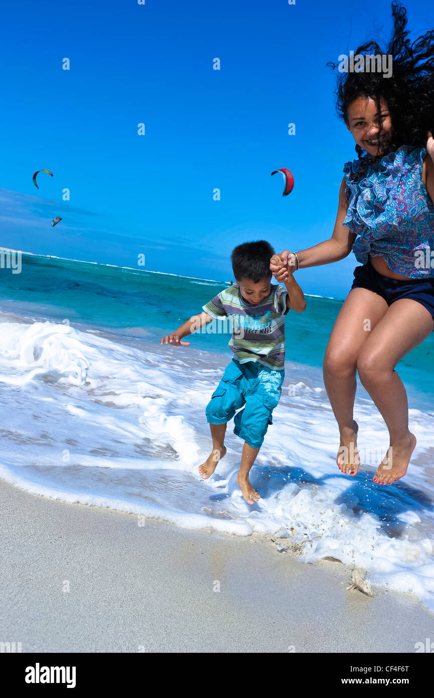 Girl with child at hand jumping Stock Photo - Alamy