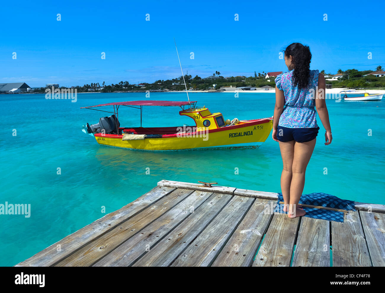 Girl on pier on Baby Beach in Aruba Stock Photo - Alamy