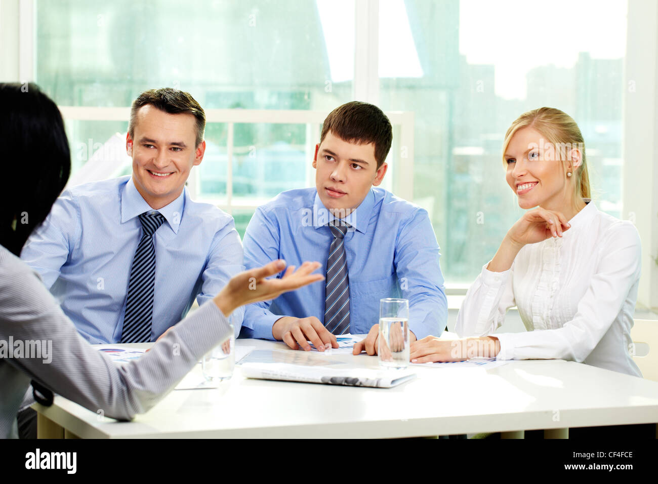 Positive business people listening attentively to their leader Stock ...