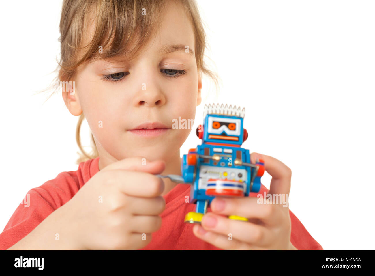 pretty little girl in red T-shirt plays with clockwork robot isolated ...