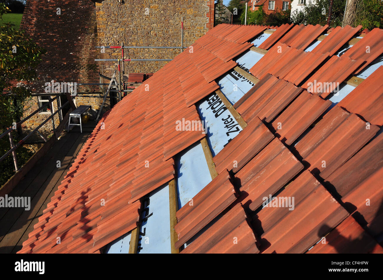 A roof under construction with the tiles being fitted UK Stock Photo ...
