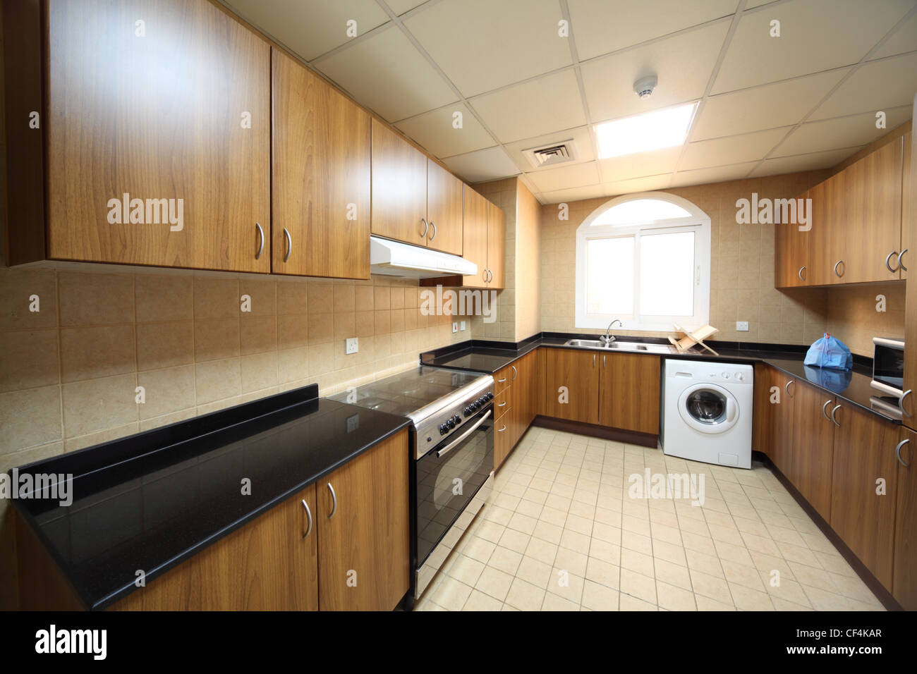 kitchen with brown cupboards, washingmachine and cooker Stock Photo - Alamy