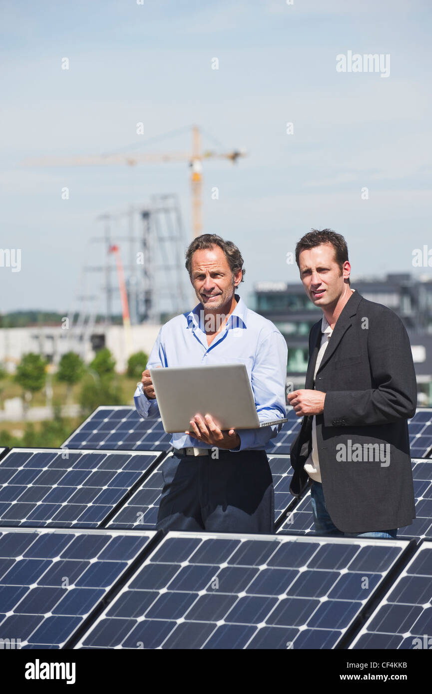 Germany, Munich, Engineer and man discussing in solar plant Stock Photo ...