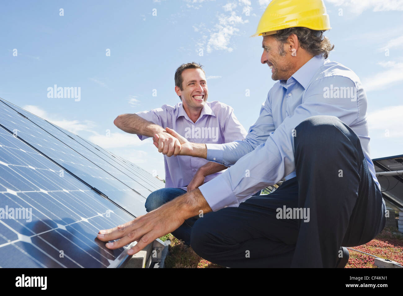 Germany, Munich, Man shaking hands with engineer in solar plant ...