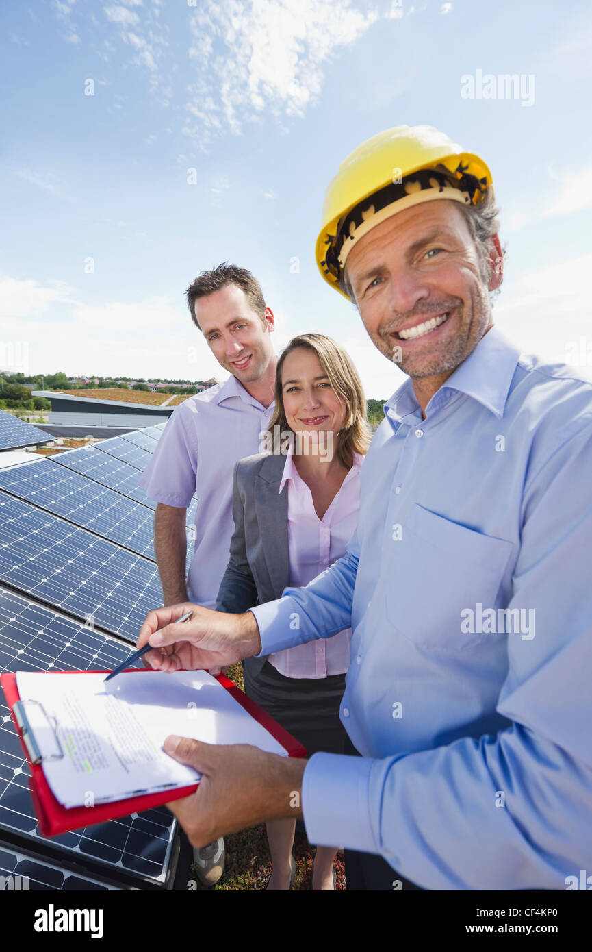 Germany, Munich, Engineer with man and woman in solar plant, smiling ...