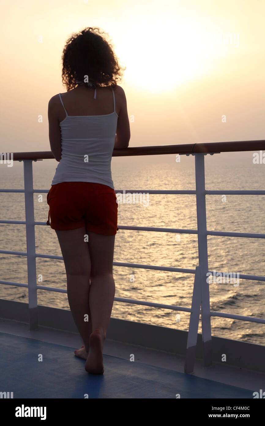 girl standing at ship deck and looking into the distance view from back ...