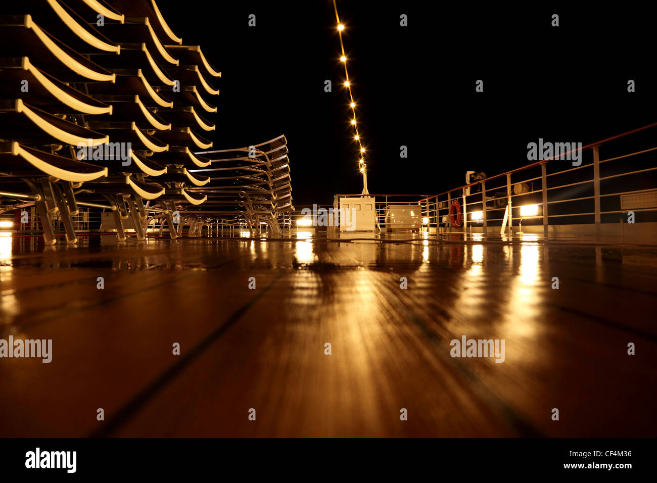 empty cruise ship deck with beach chairs and lamps at night time Stock ...